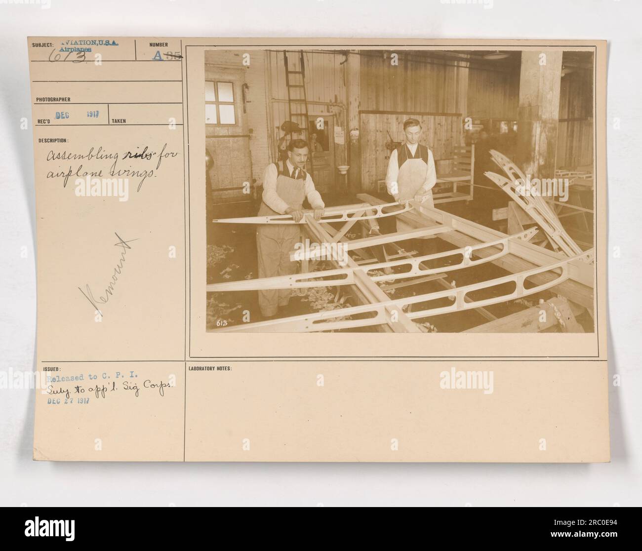 group of workers are seen here assembling ribs for airplane wings ...