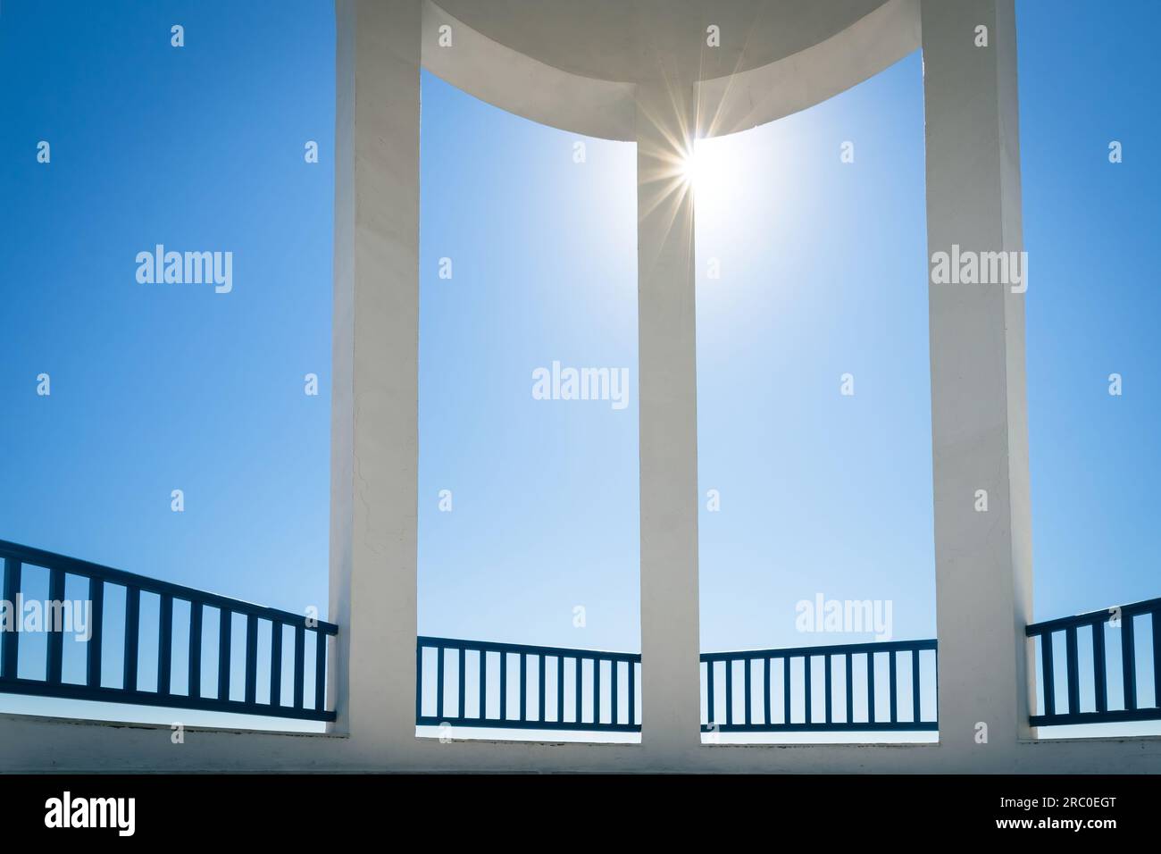 View to blue sky with the sun in shape of a star through architectural ...