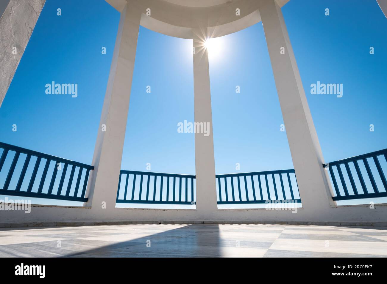View to blue sky with the sun in shape of a star through architectural ...