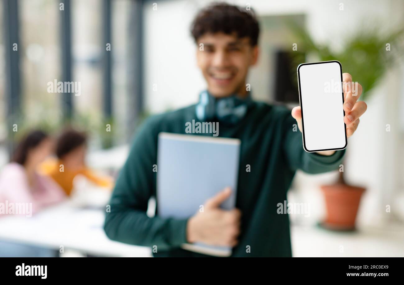 Educational advertisement. Happy male student showing smartphone with ...