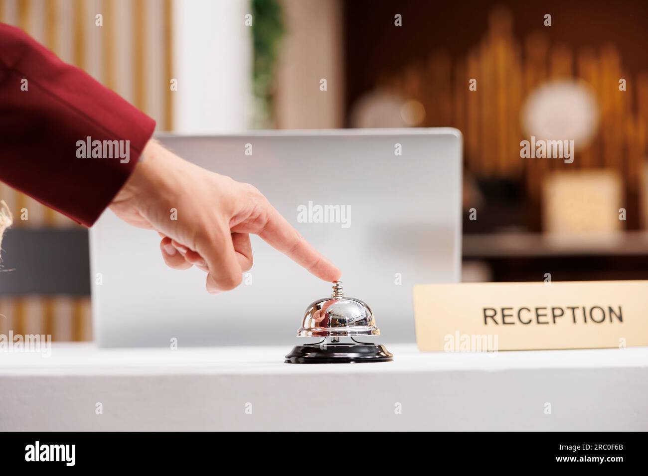 Guest using service bell at reception, ringing for assistance from ...