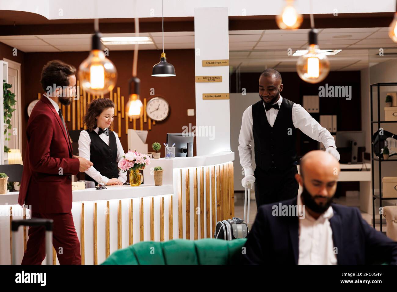 Bellboy assisting businessman after check in, providing concierge ...
