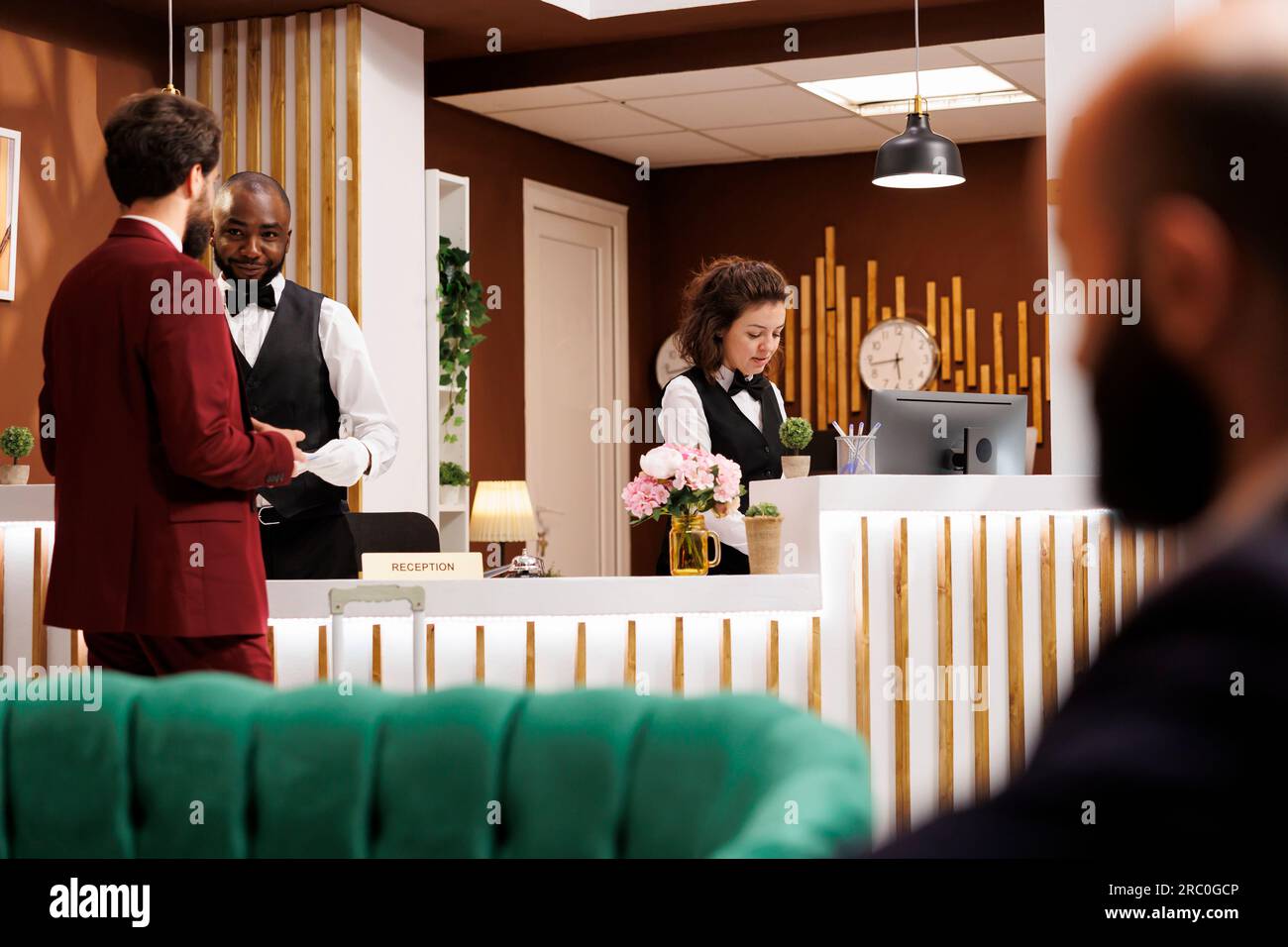 Hotel staff welcome businessman in lobby, ensuring seamless and ...