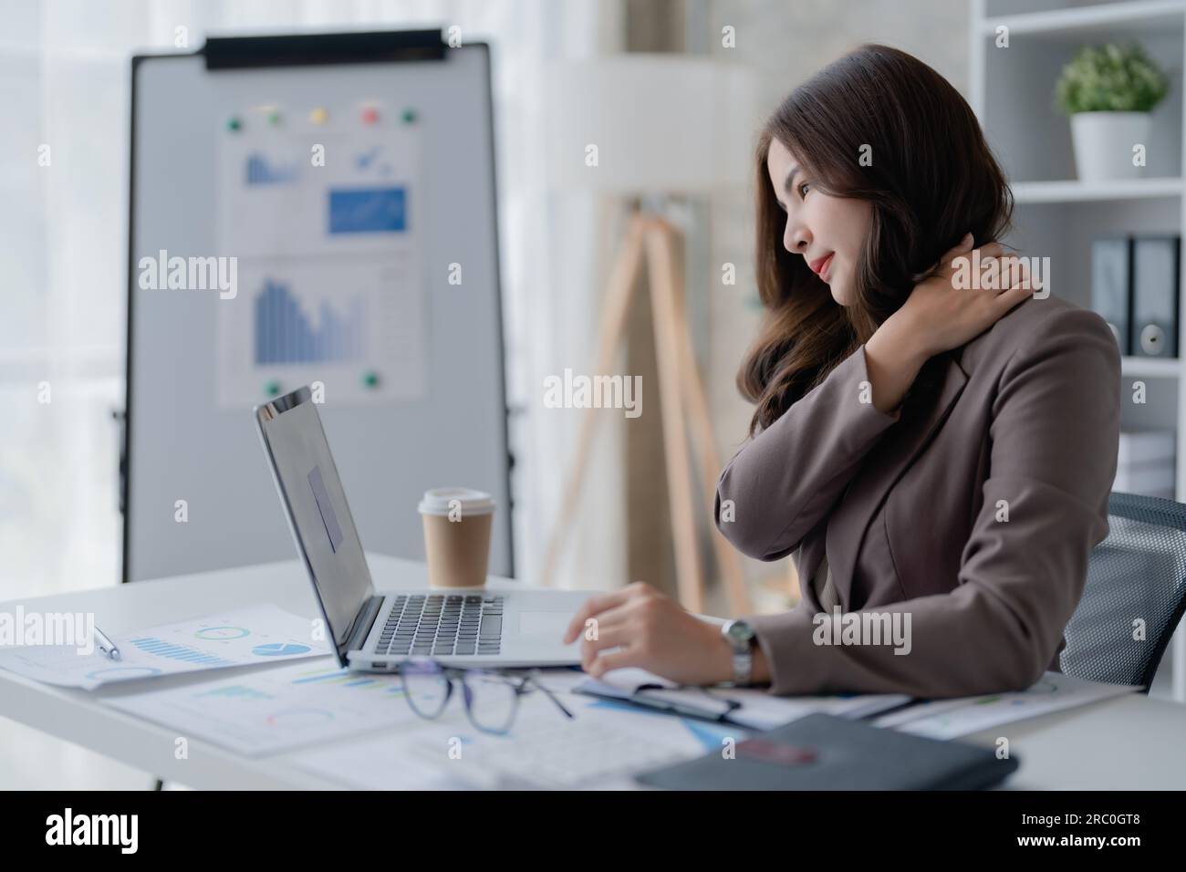 Portrait of a young Asian woman suffering from acute headache and ...