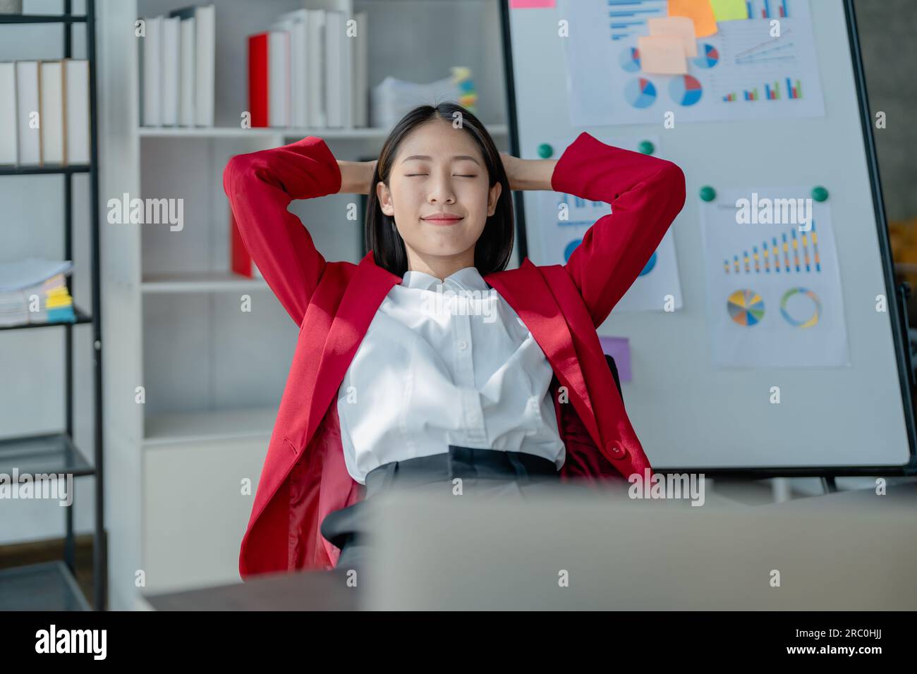 Rear view young businesswoman leaning back in comfortable chair ...