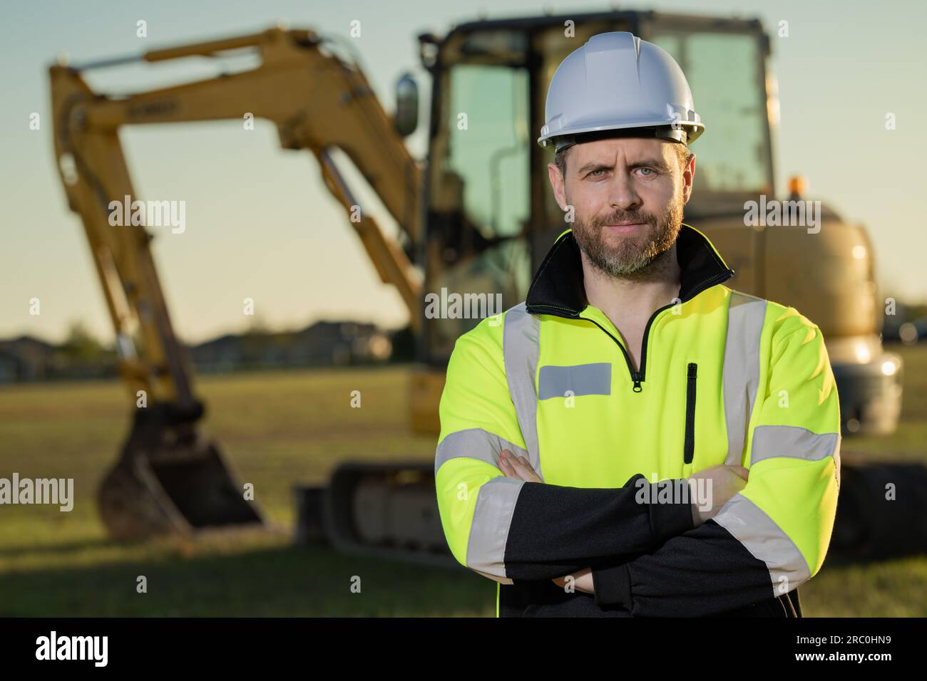 Portrait of builder in a construction site. Builder with excavator ...