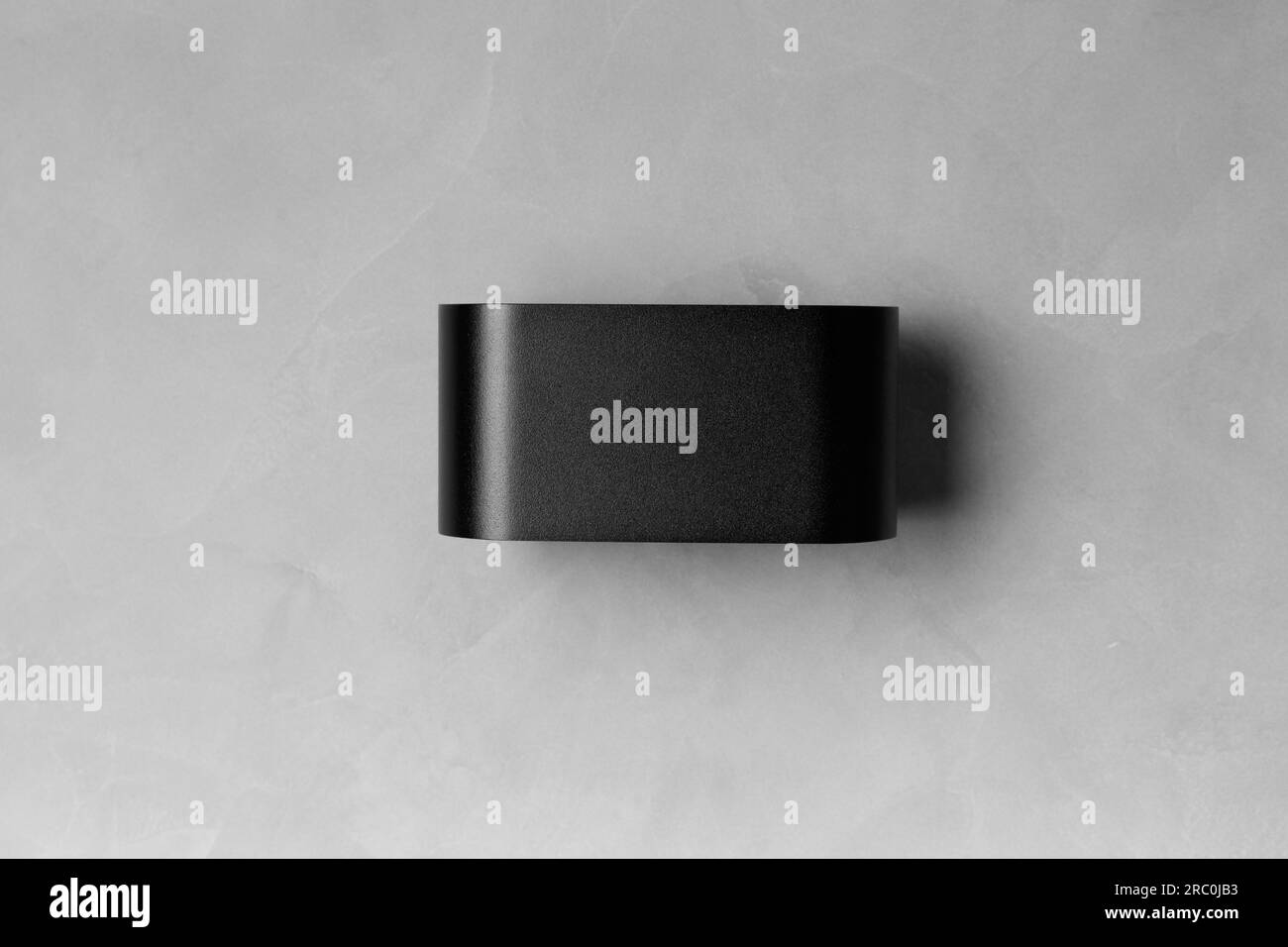 Modern black wall lamp on a gray texture wall with a place for the text ...