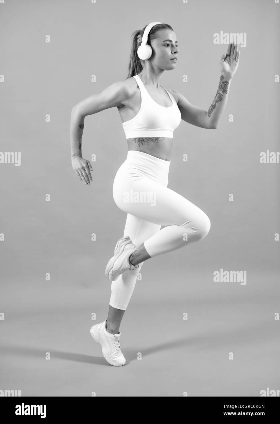 Young fitness woman runner with headphone run, isolated on gray ...