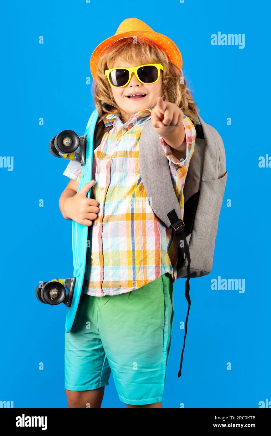 Child boy holding longboard on blue isolated background. Kid with ...