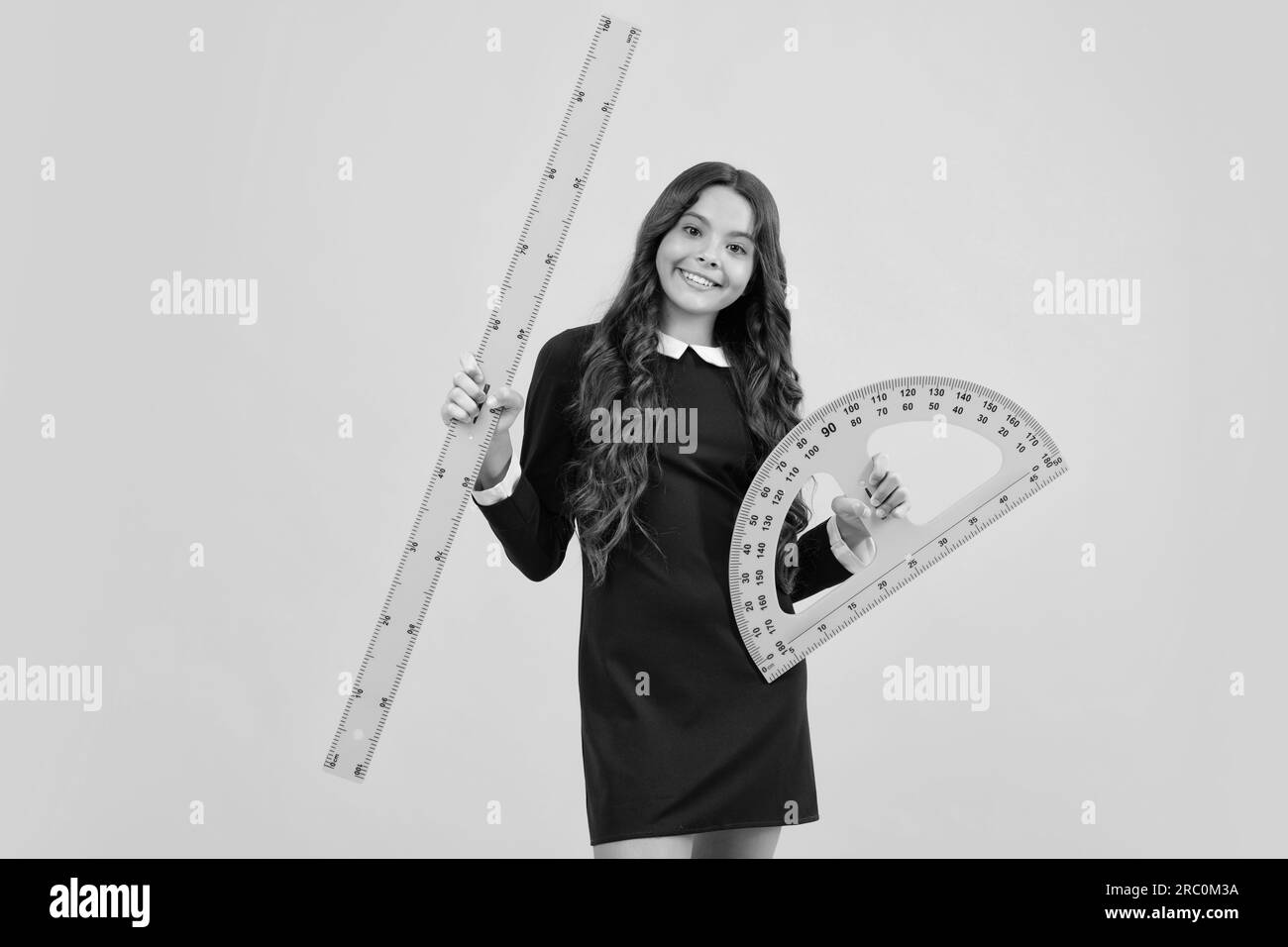 Back to school. School girl hold ruler measuring isolated on yellow ...