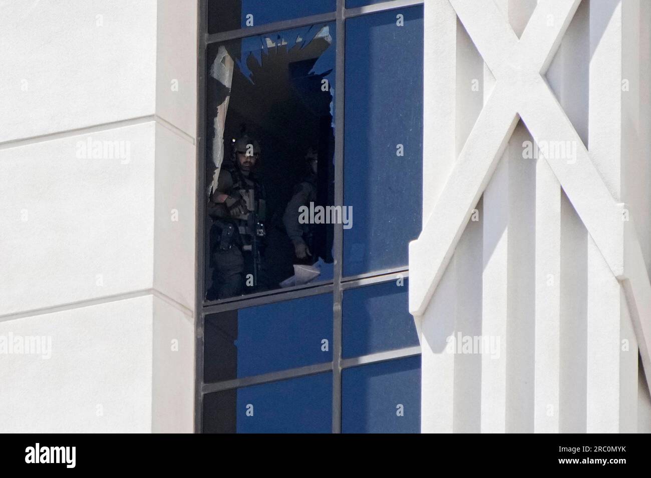 A police officer looks out of a broken window on a hotel tower at ...