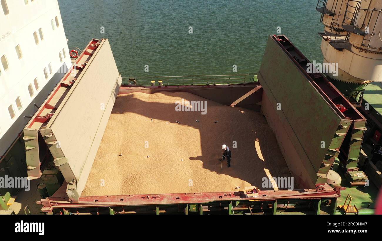 Pest control service workers doing fumigation in cargo hold of grain ...