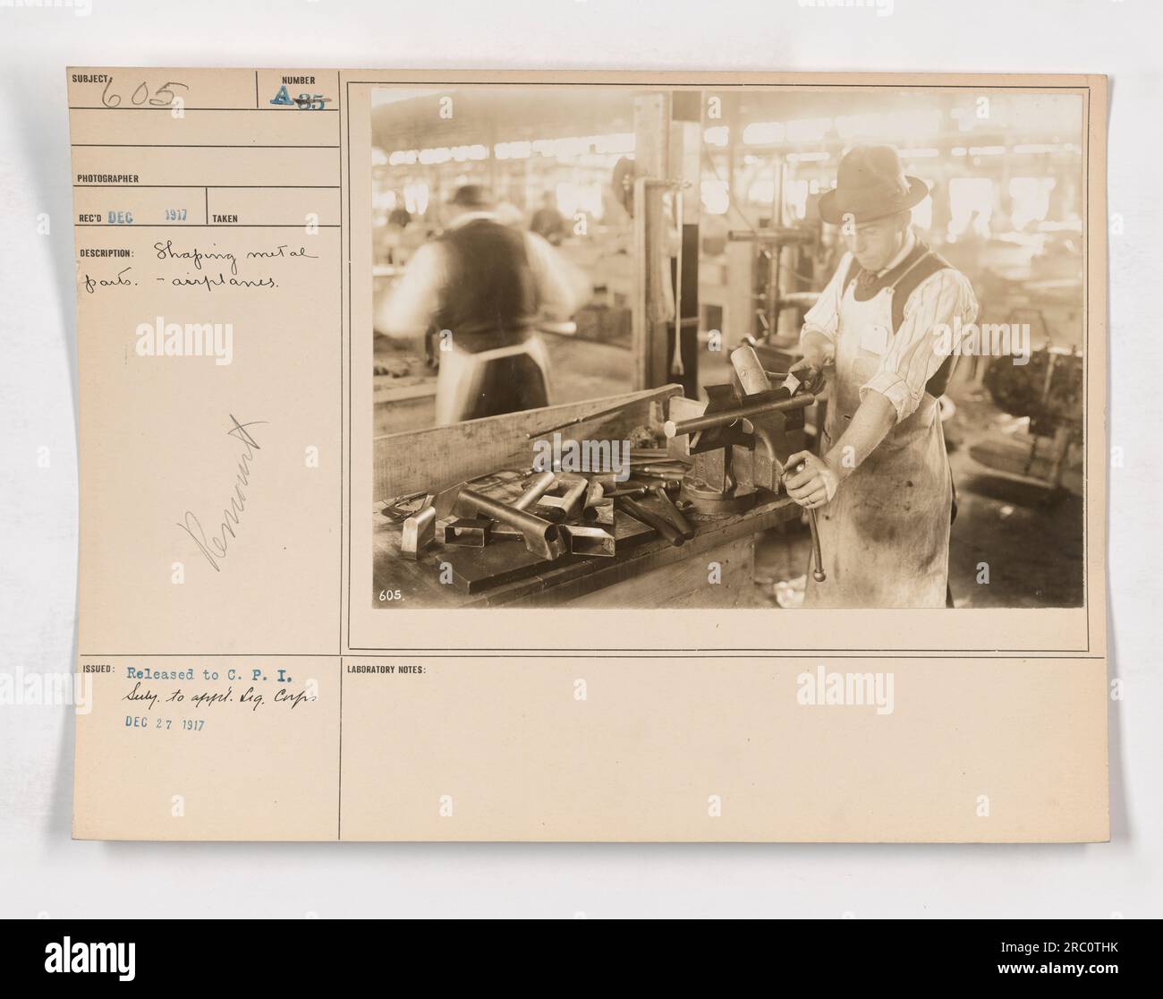 A worker shaping metal parts for airplane production during World War ...