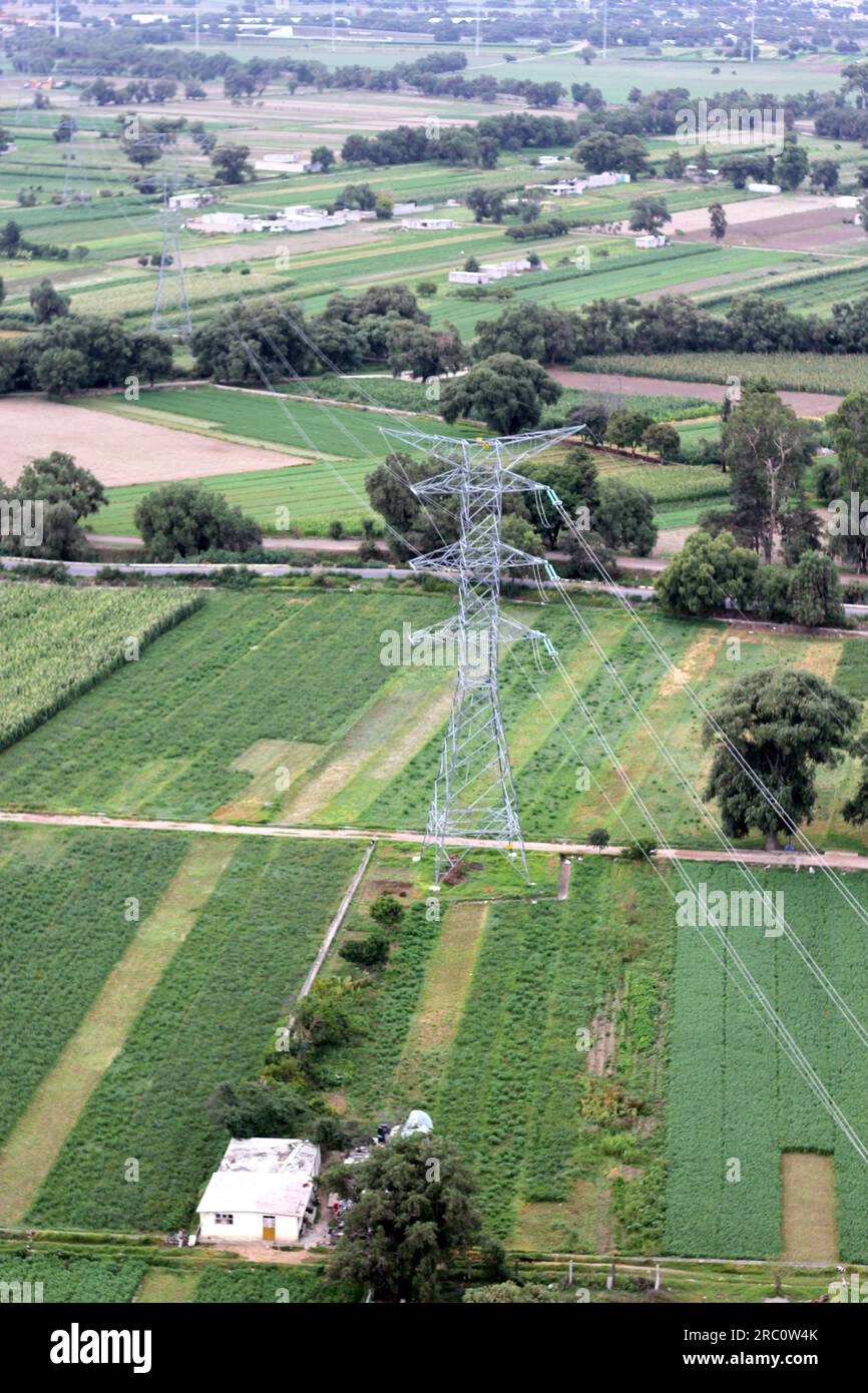 View of electric tower and high voltage cables in the middle of green ...