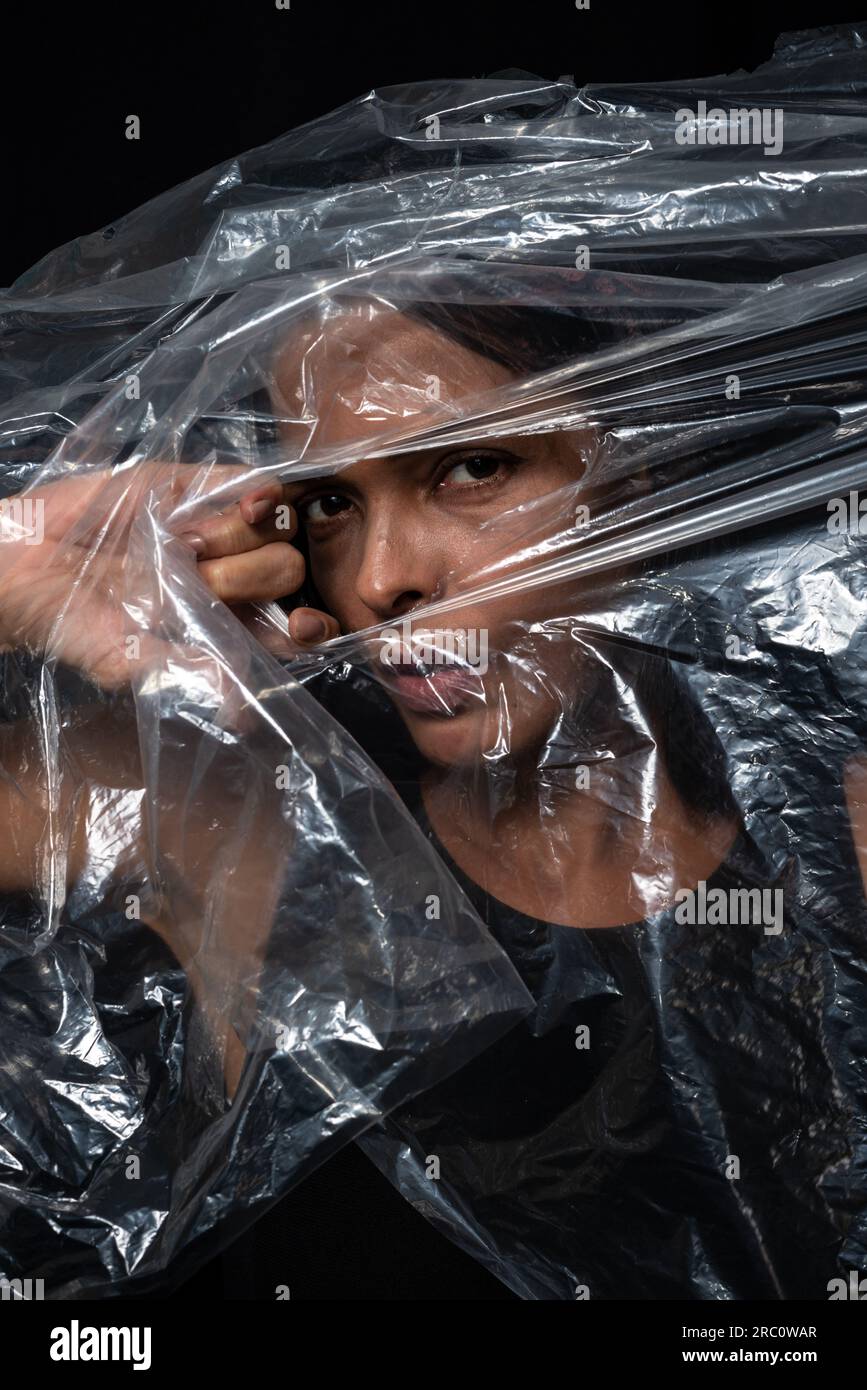 A woman with a plastic bag over her head looking through a hole ...