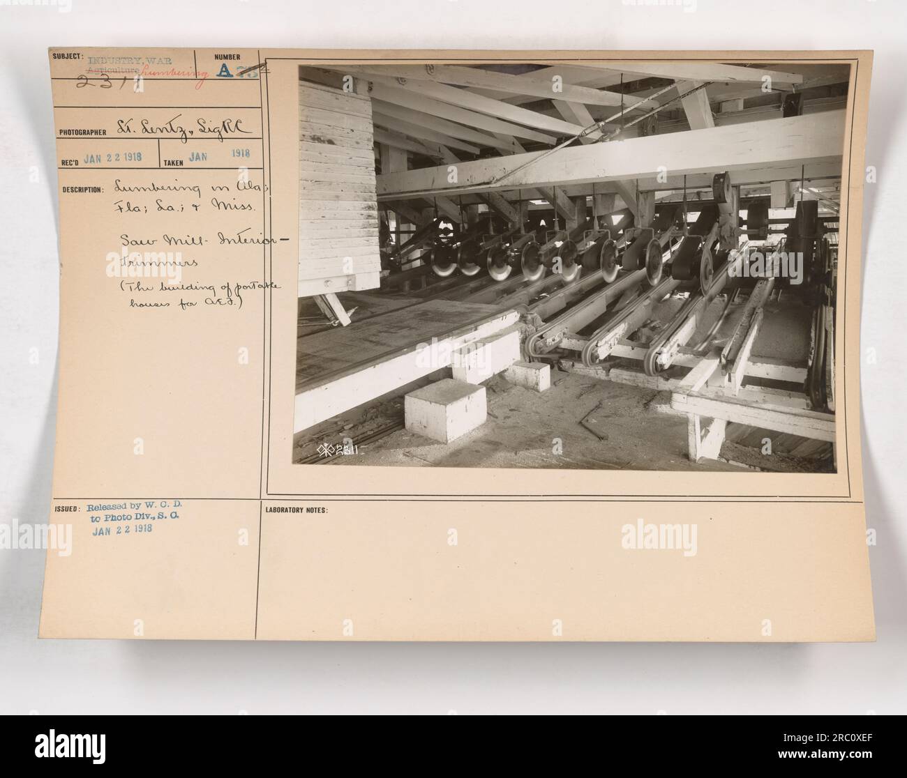 Caption: Interior of a sawmill showing trimmers building portable ...