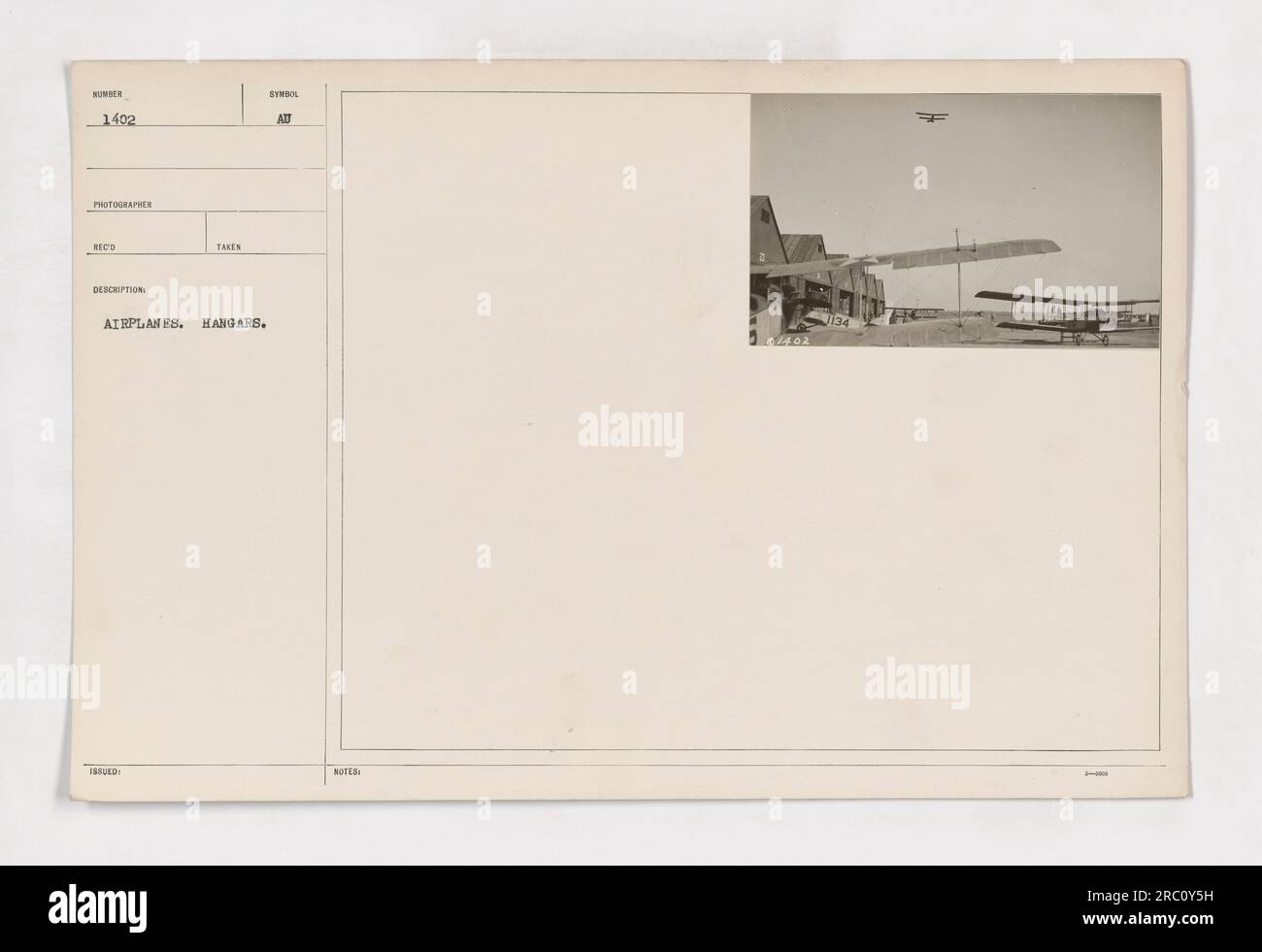 The image shows several airplane hangars during World War One. The ...
