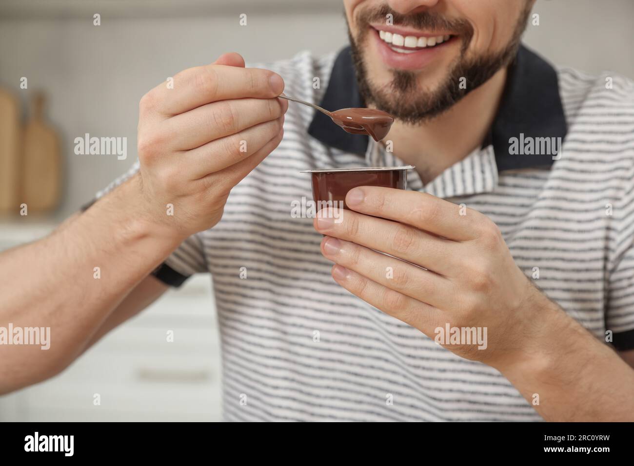 Man eating yogurt in kitchen hi-res stock photography and images - Alamy