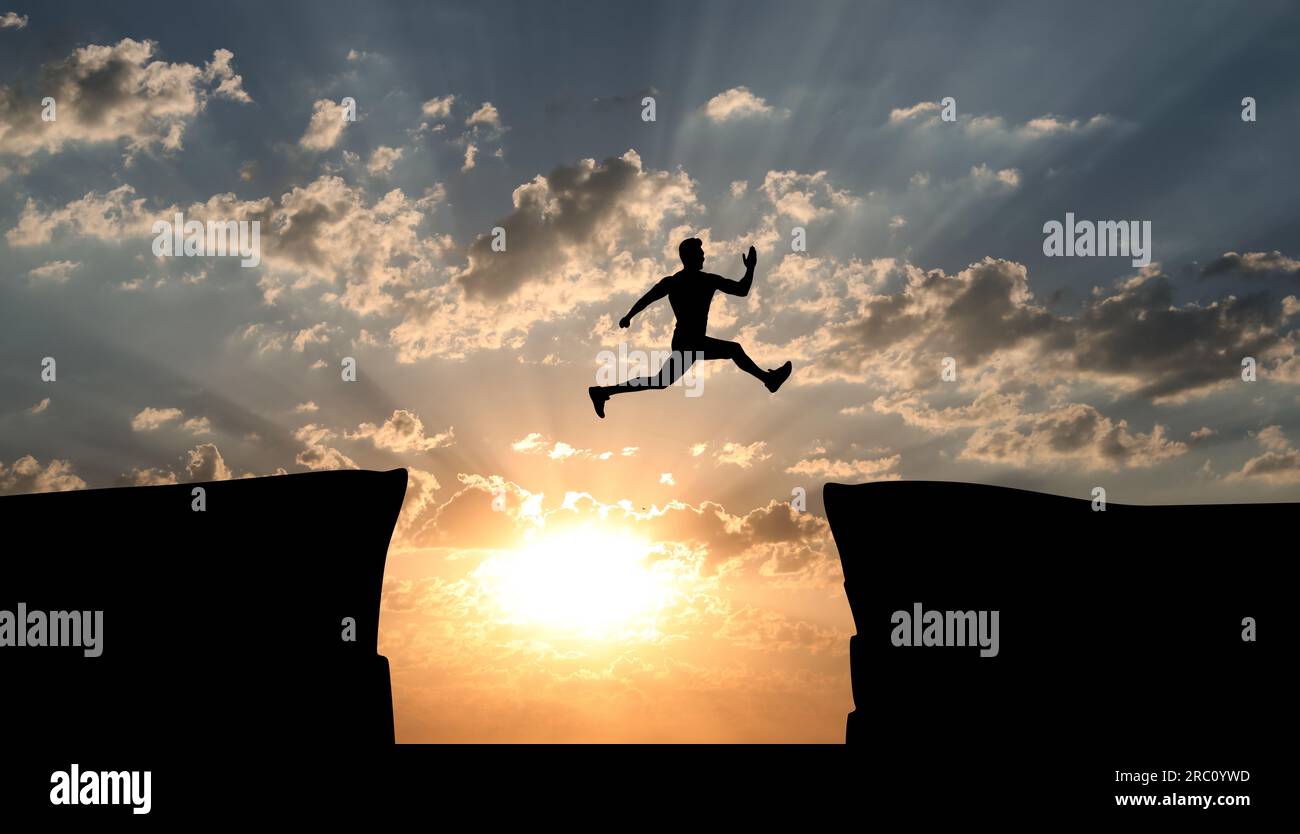 Concept of reaching life and business goals. Silhouette of man jumping ...