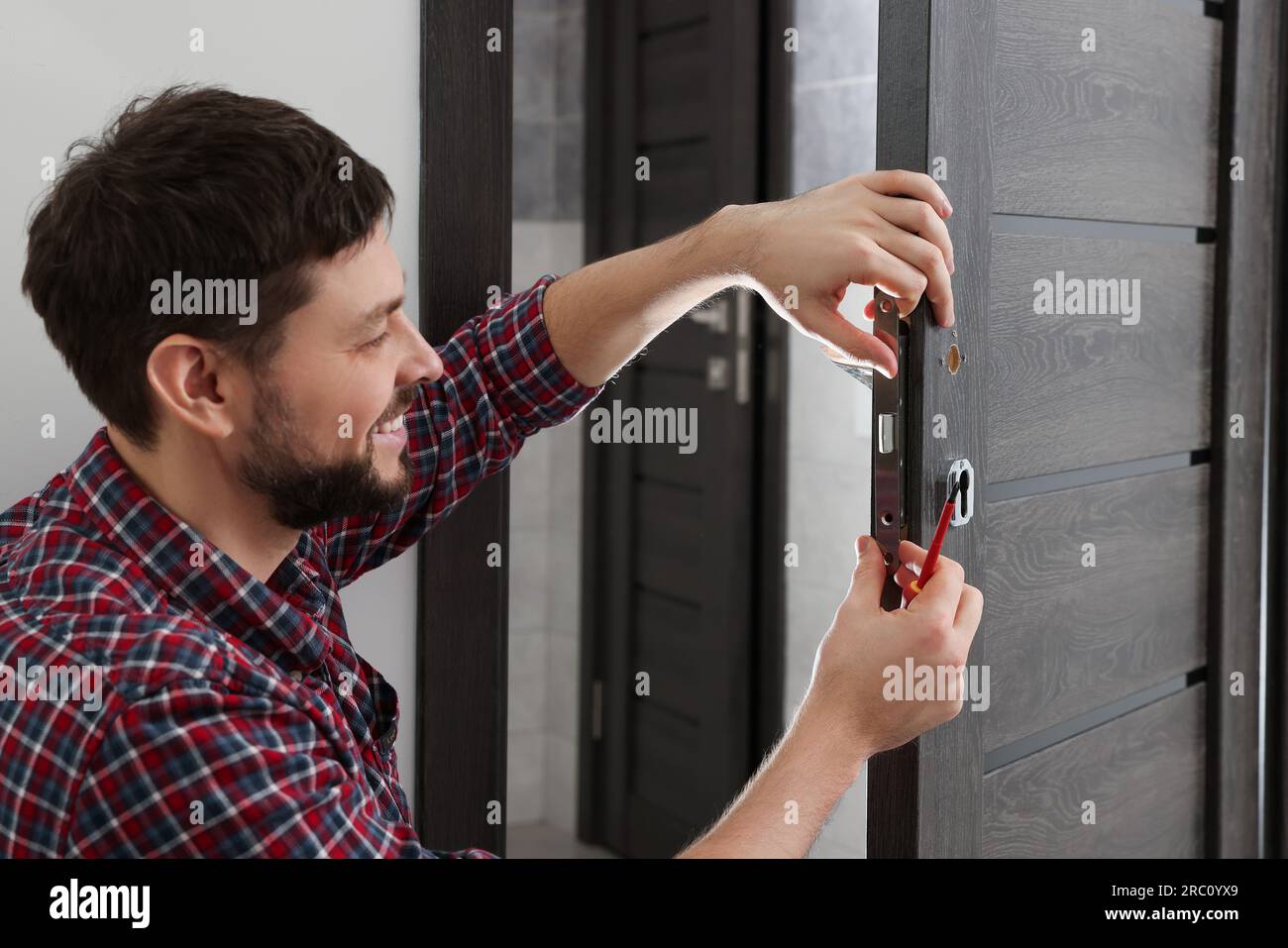 Happy handyman fixing door hi-res stock photography and images - Alamy