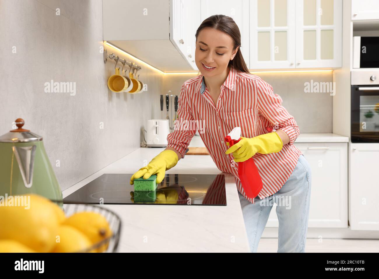 Spring cleaning. Young woman tidying up kitchen at home Stock Photo - Alamy