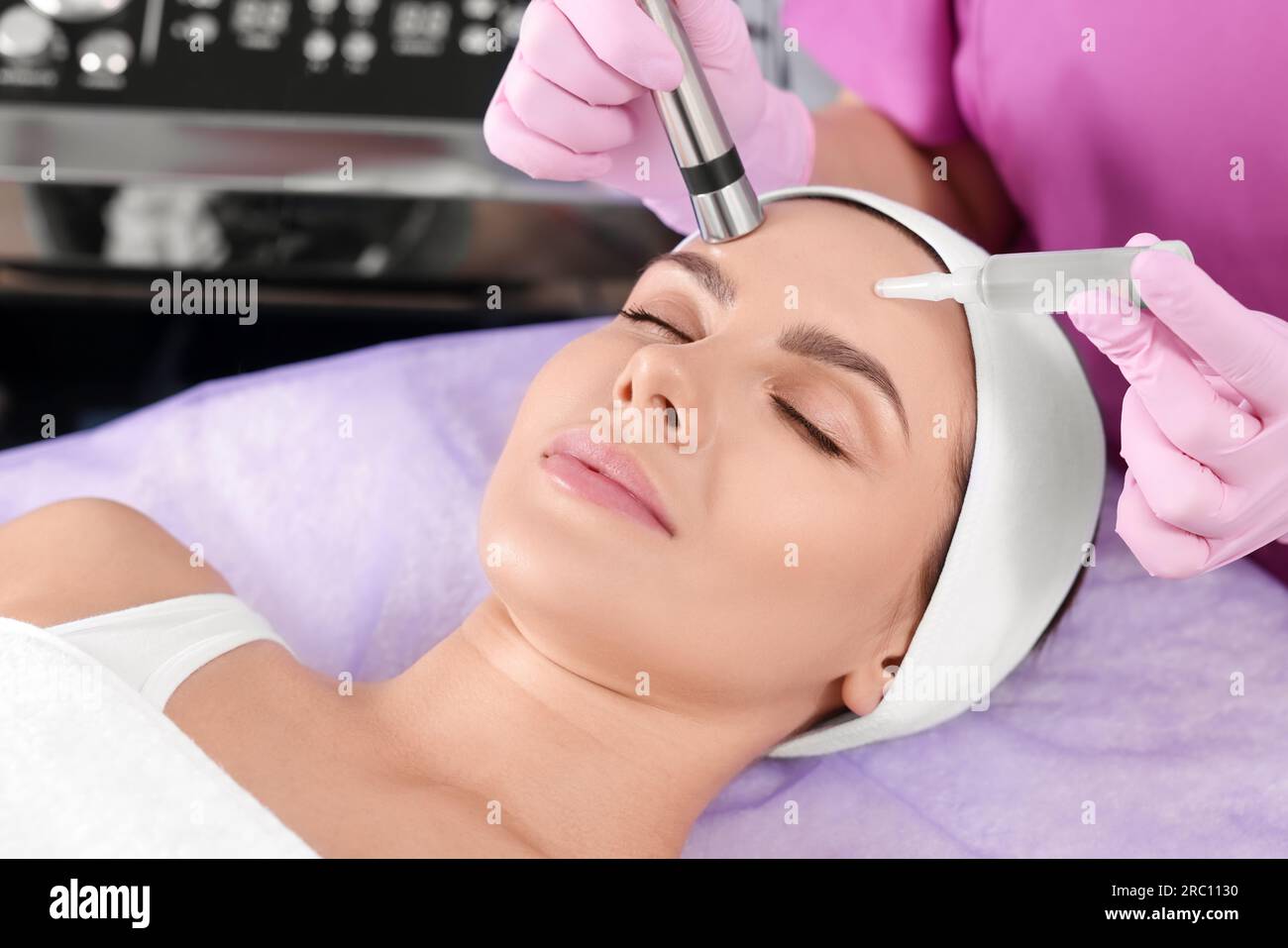 Young woman undergoing cosmetic procedure in beauty salon. Microcurrent ...