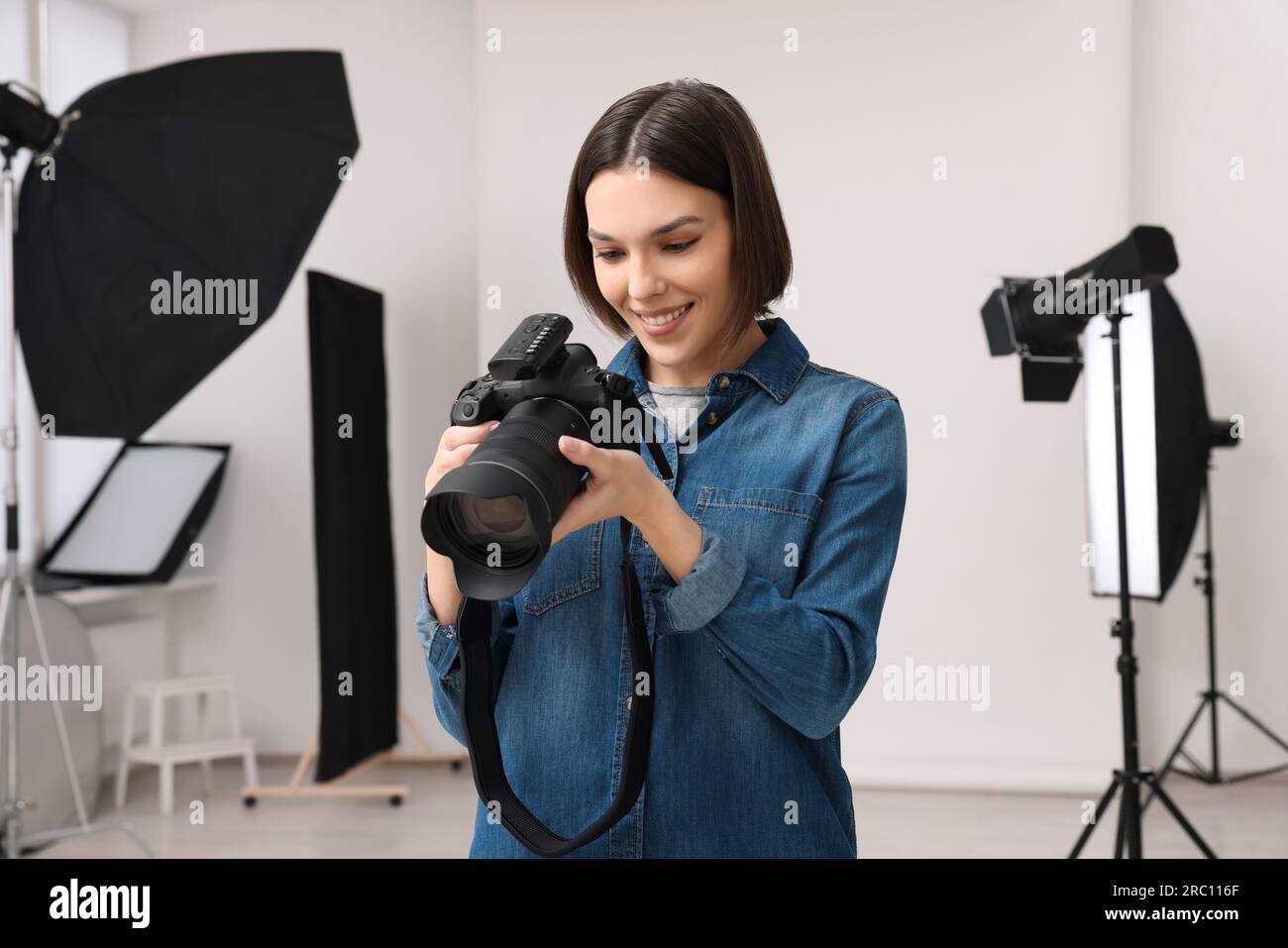 Professional photographer with camera in modern photo studio Stock ...