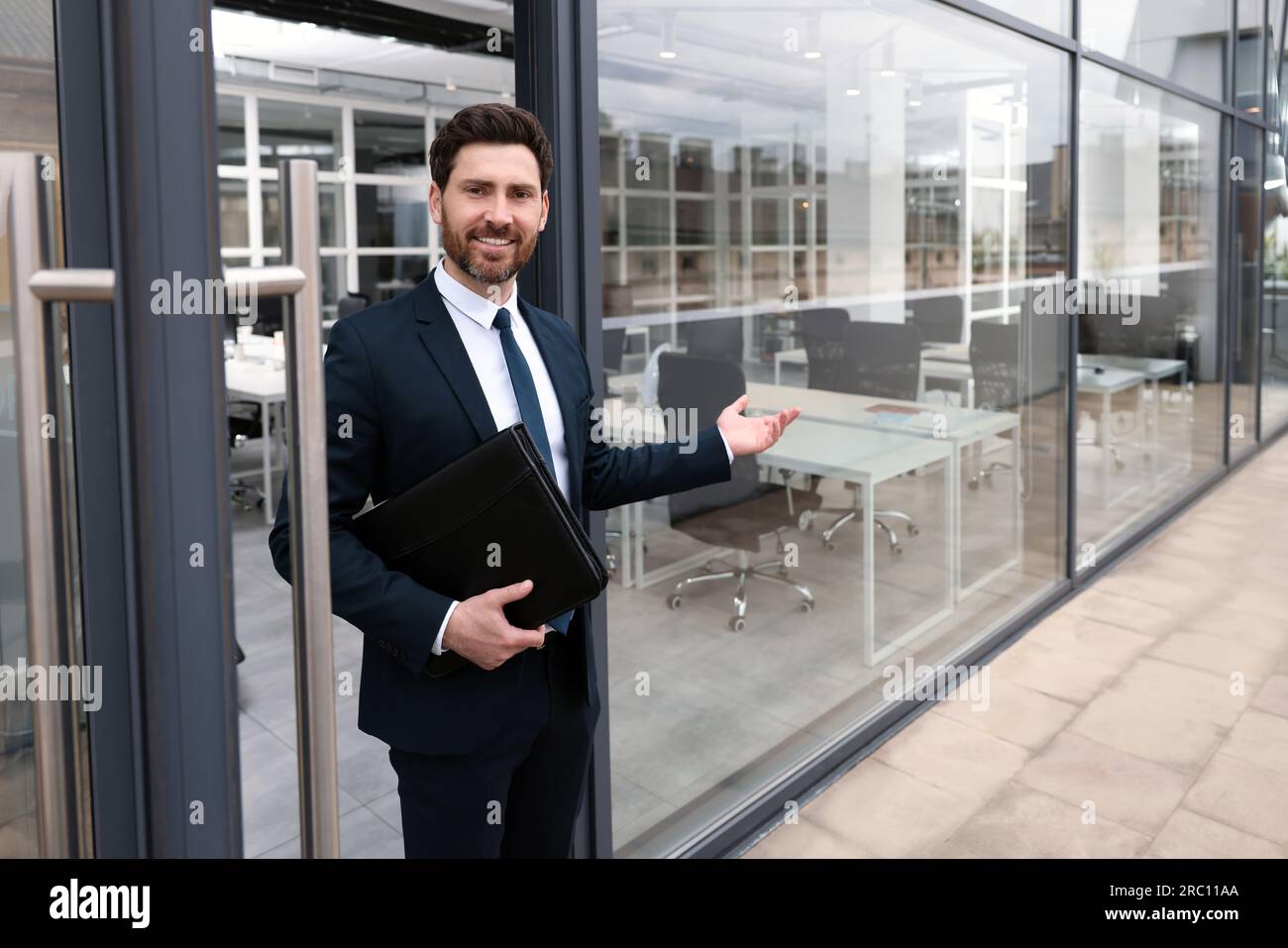 Male real estate agent with leather portfolio inviting inside Stock ...