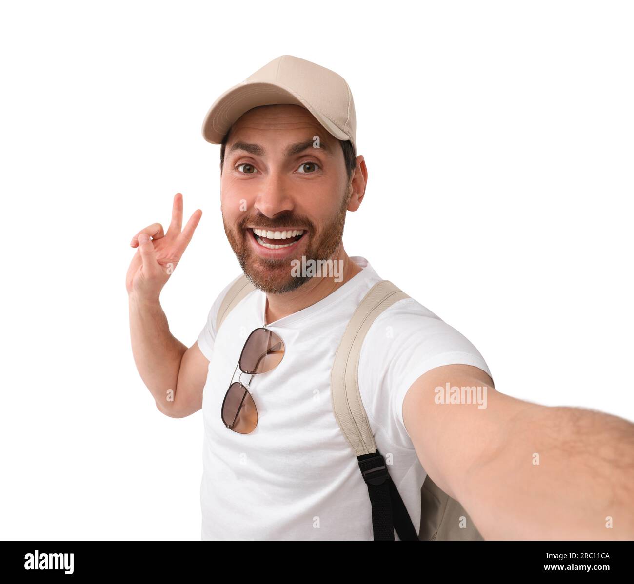 Smiling man taking selfie and showing peace sign on white background ...