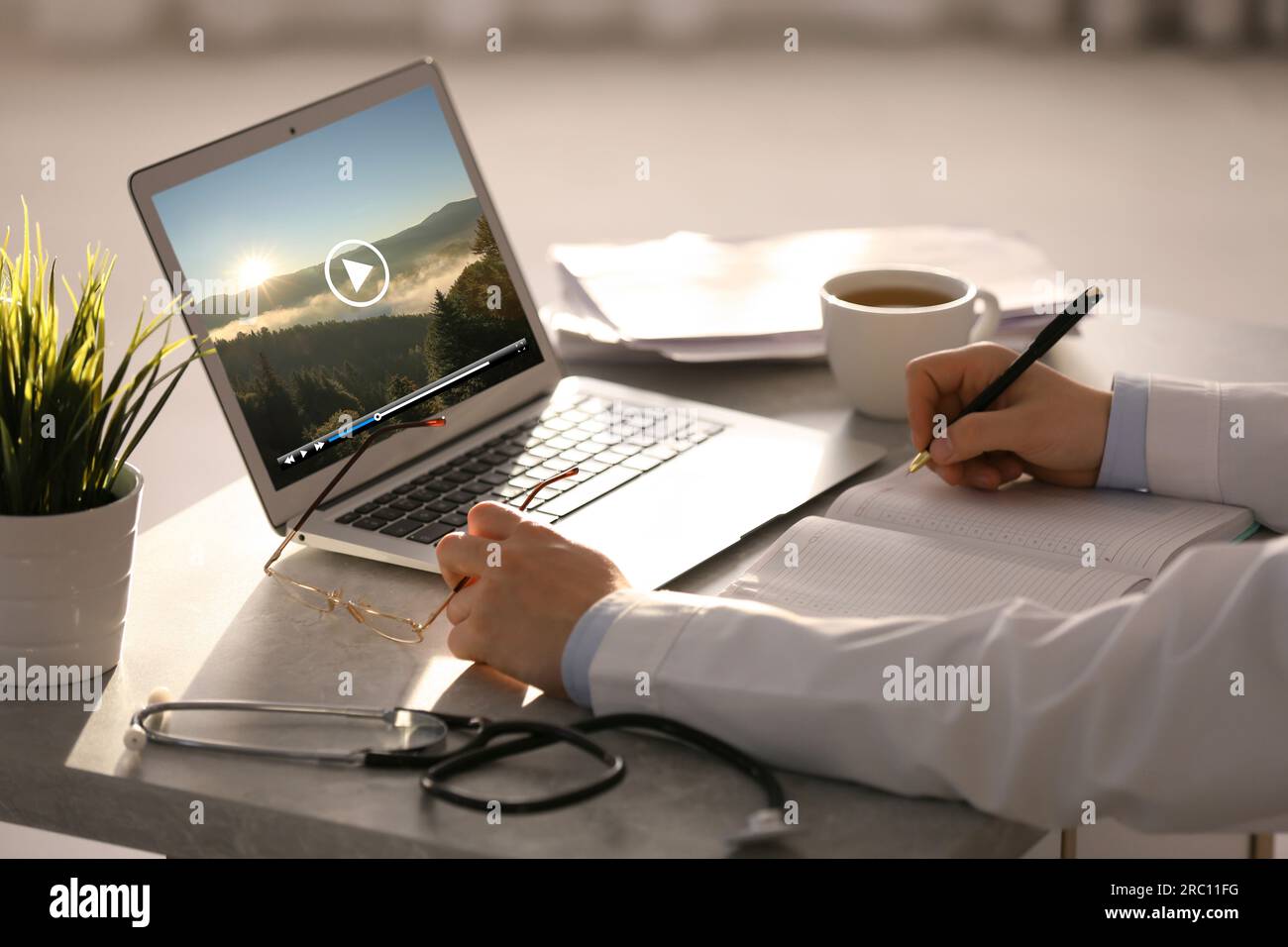 Doctor watching video on laptop at office desk, closeup. Man choosing ...