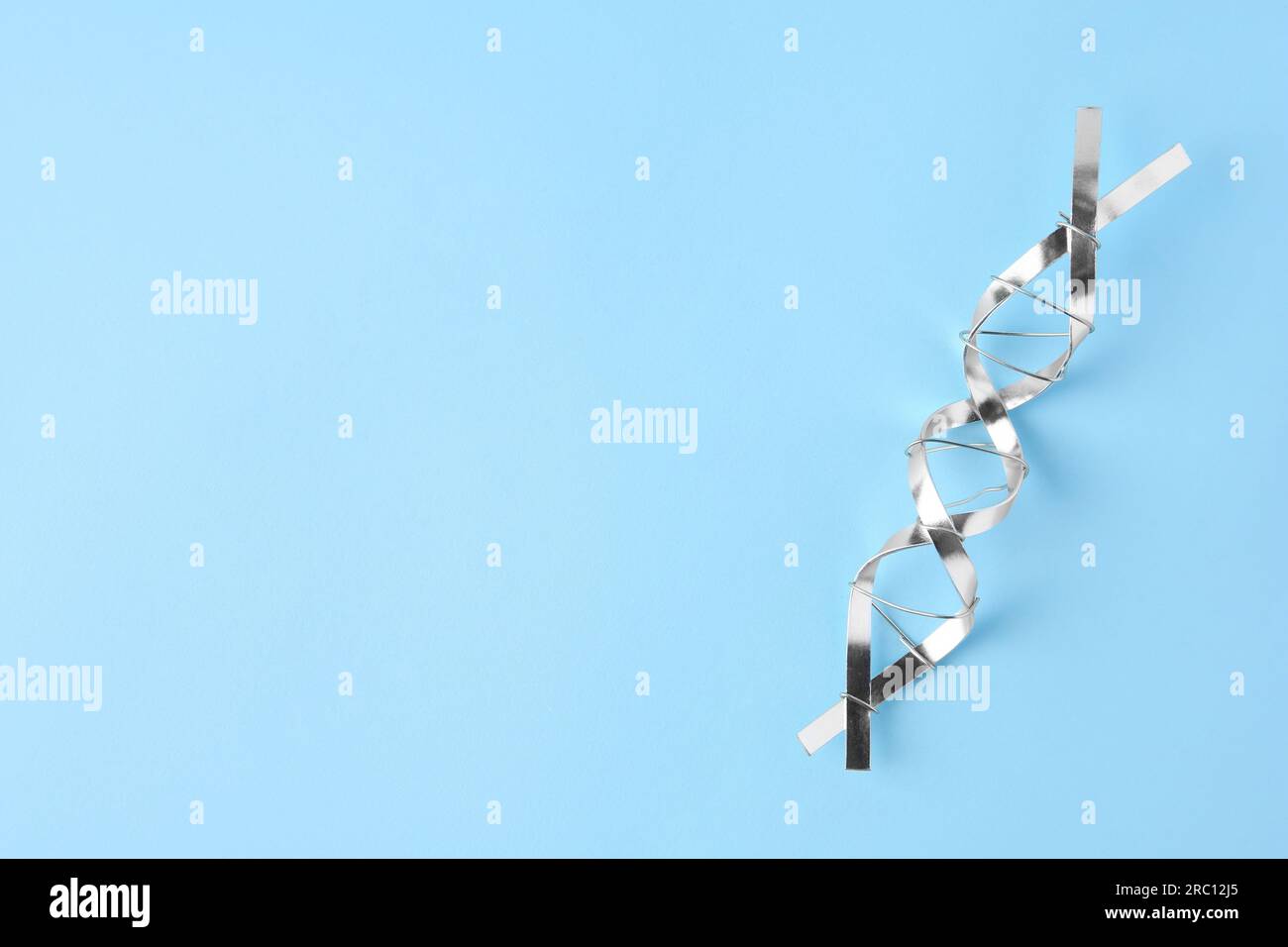 DNA molecular chain model made of metal on light blue background, top ...