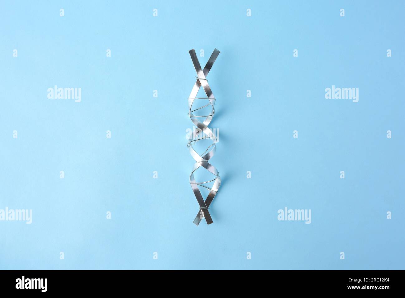 DNA molecular chain model made of metal on light blue background, top ...