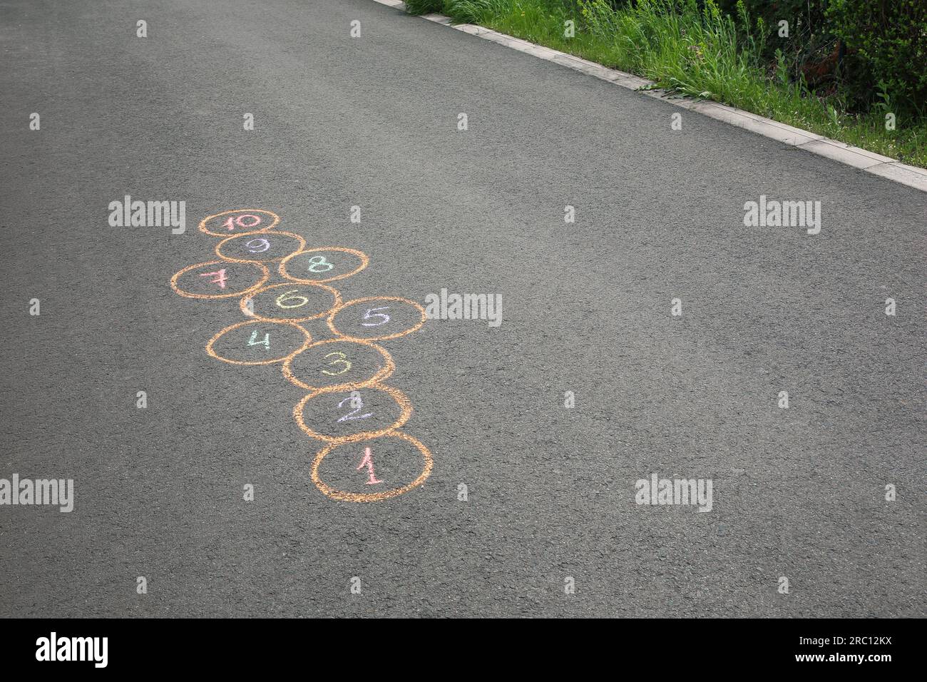 Hopscotch drawn with colorful chalk on asphalt outdoors. Space for text ...