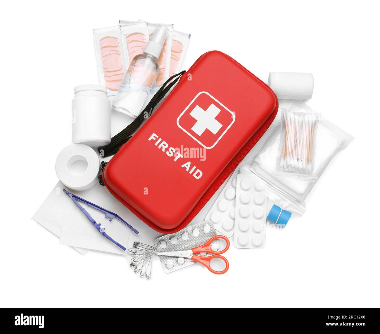 Red first aid kit, scissors, cotton buds, pills, plastic forceps, hand ...