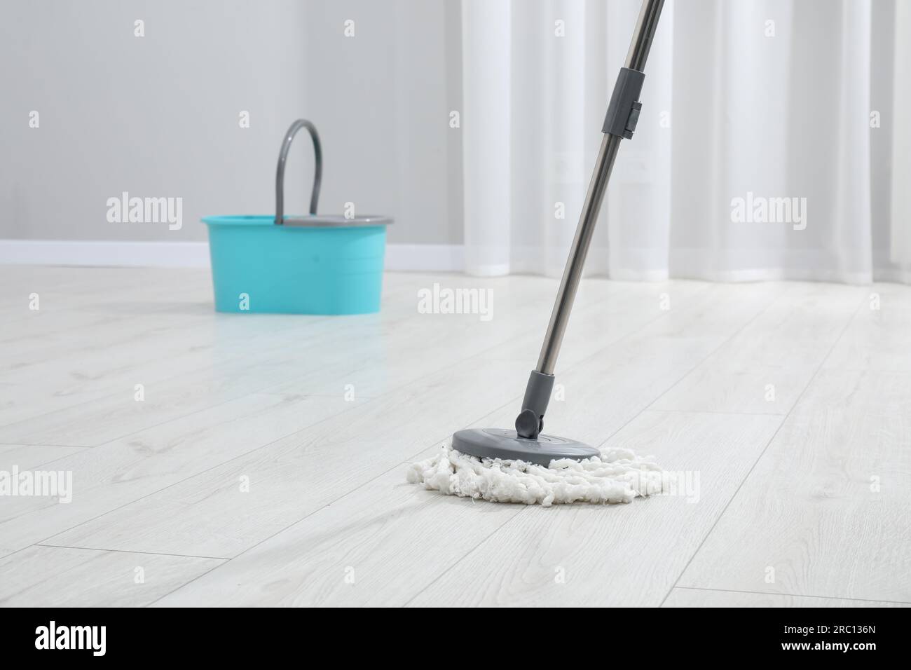 Cleaning dirty wooden floor with mop indoors Stock Photo - Alamy
