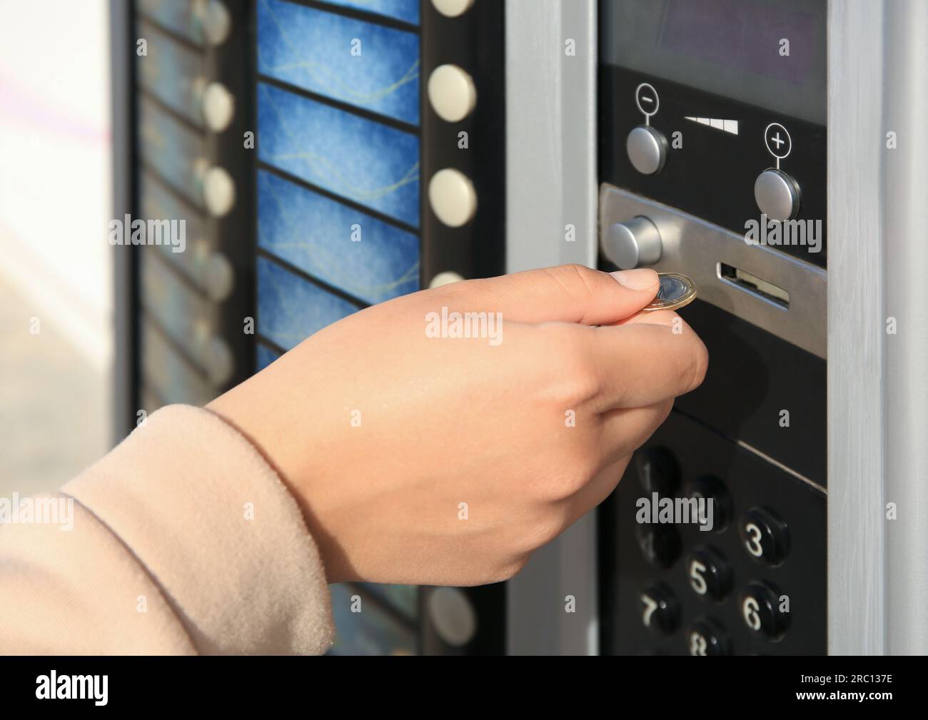Using coffee vending machine. Woman inserting coin to pay for drink ...
