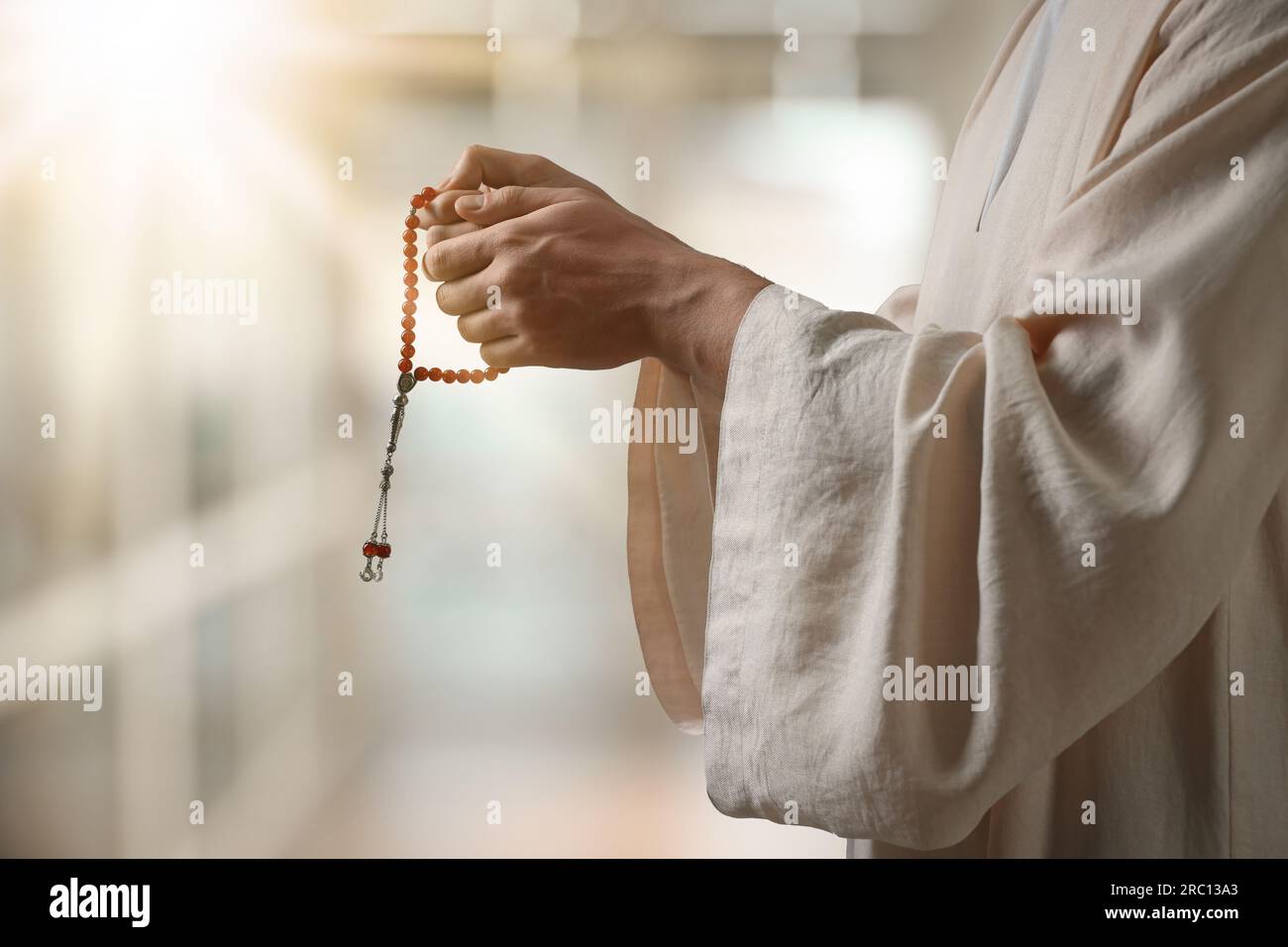 Muslim man with misbaha praying on blurred background, closeup Stock ...