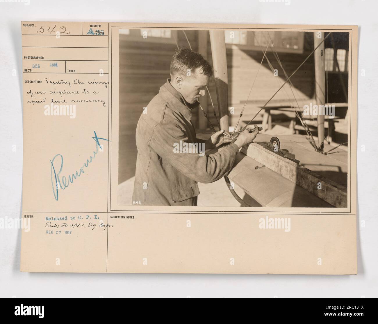 Workers in an airplane production facility truing the wings of an ...