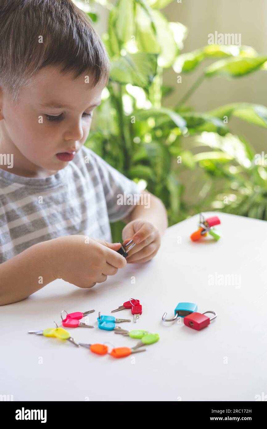 The child works with Montessori material with colored locks. Picks up ...