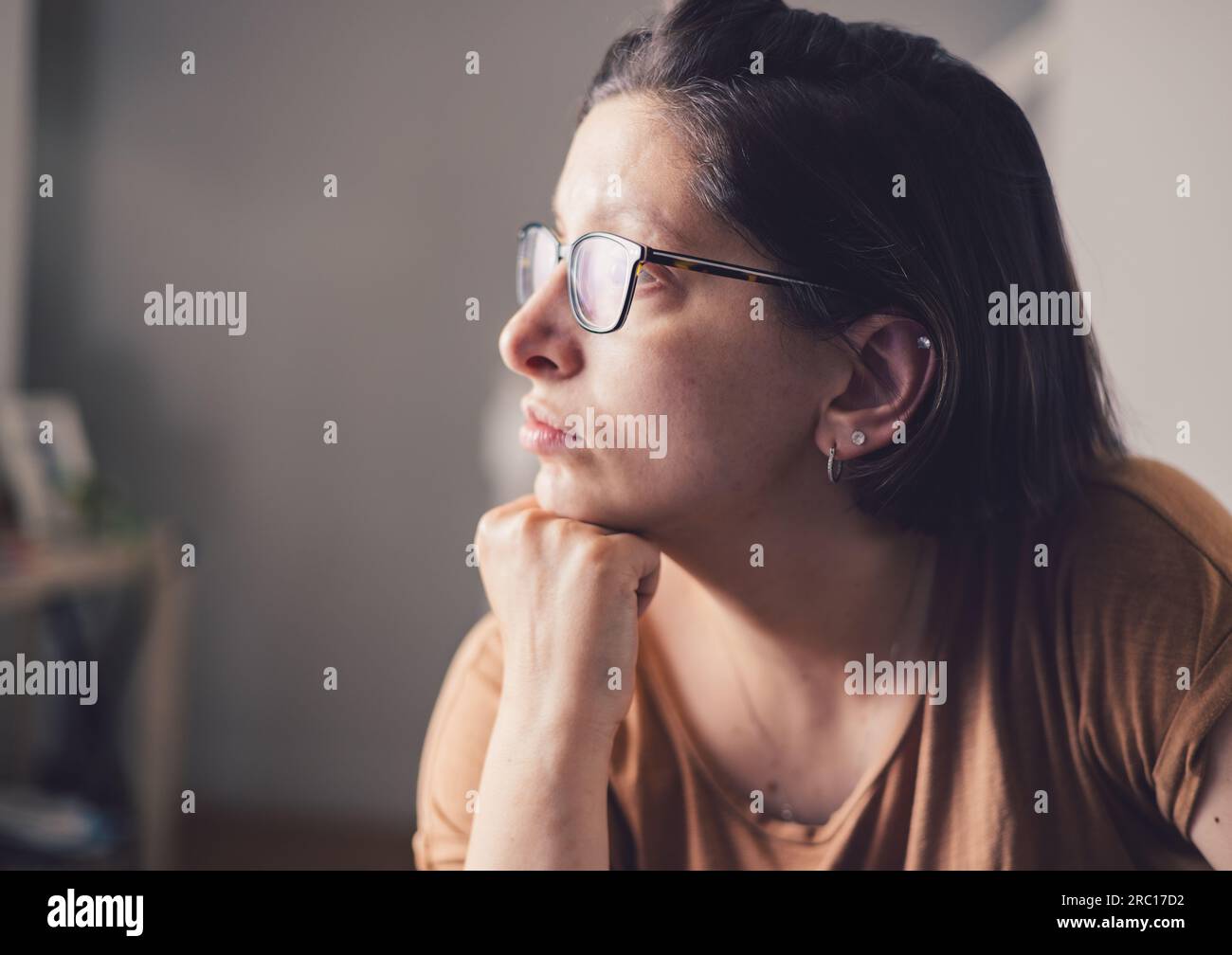 Young millennial mother at home wearing prescription glasses looking of ...