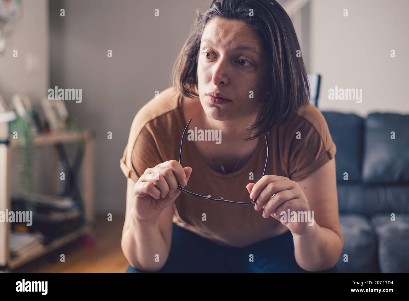 Young millennial mother at home with prescription glasses looking of ...