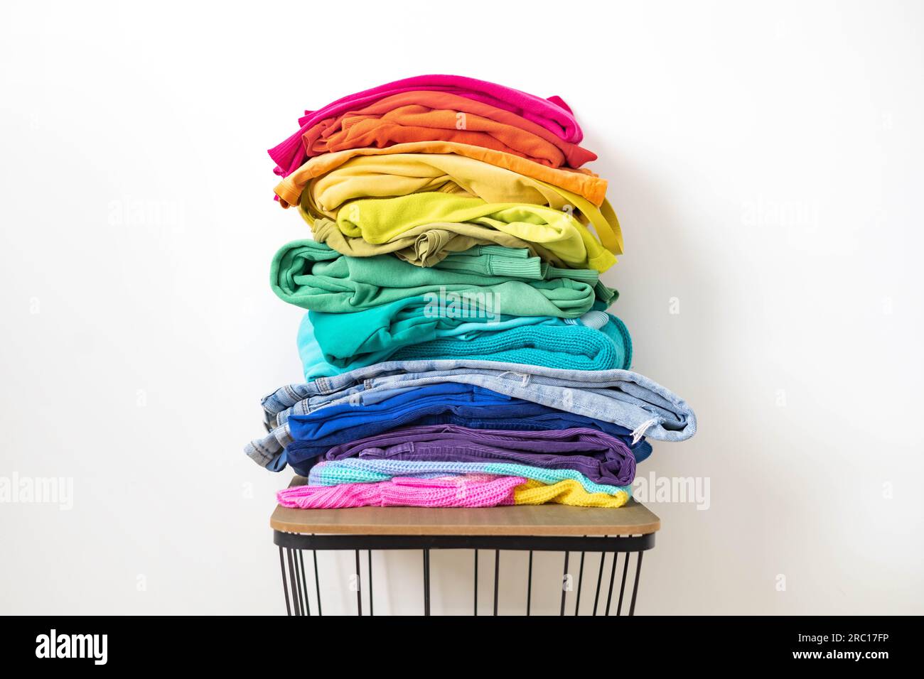 A stack of clothes in different colors. The concept of conscious ...