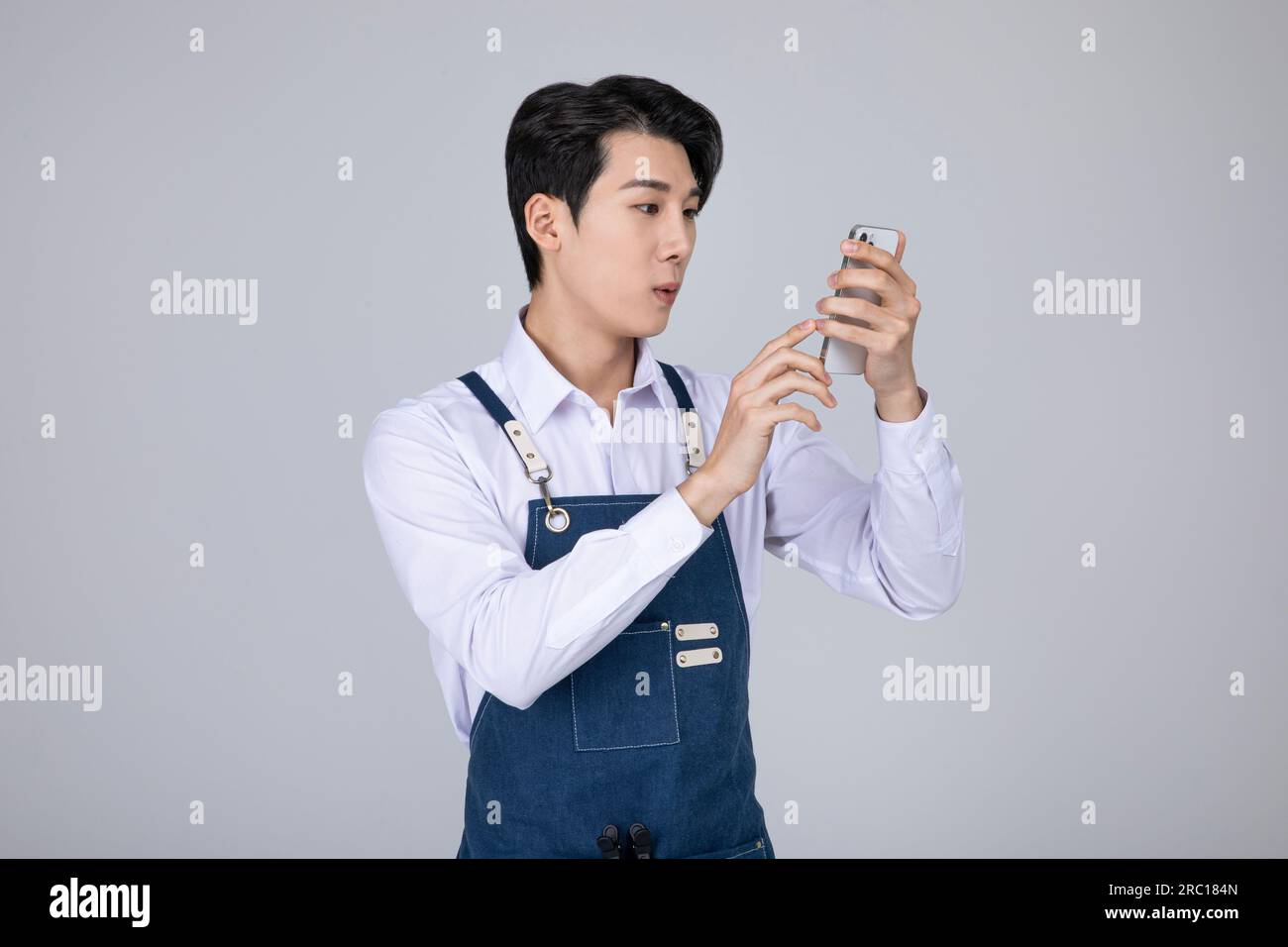 millennials and gen z, korean asian young man holding a smartphone ...
