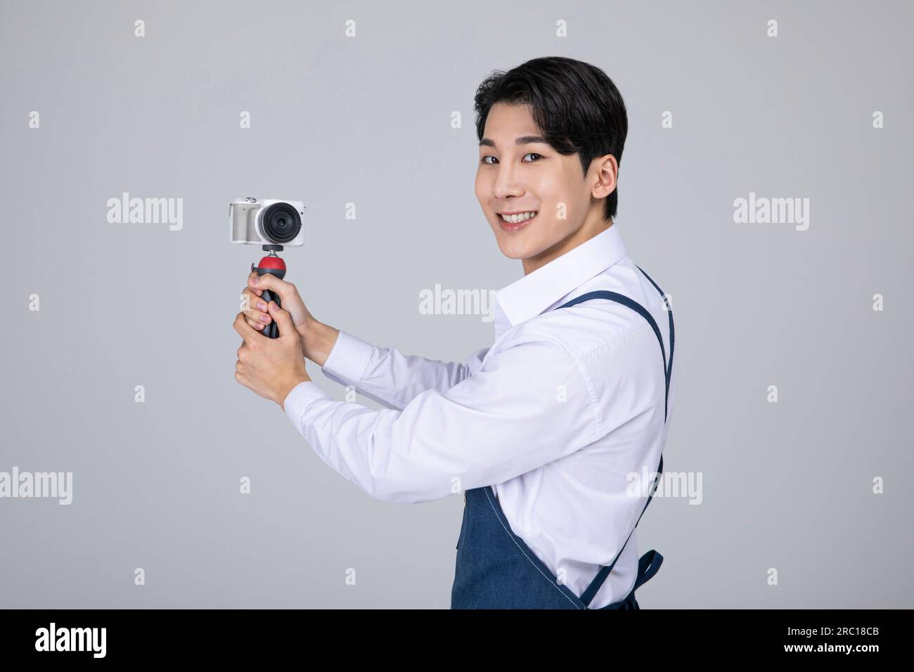 millennials and gen z, korean asian young man filming with a camera ...