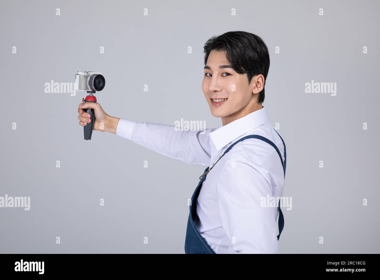 millennials and gen z, korean asian young man filming with a camera ...