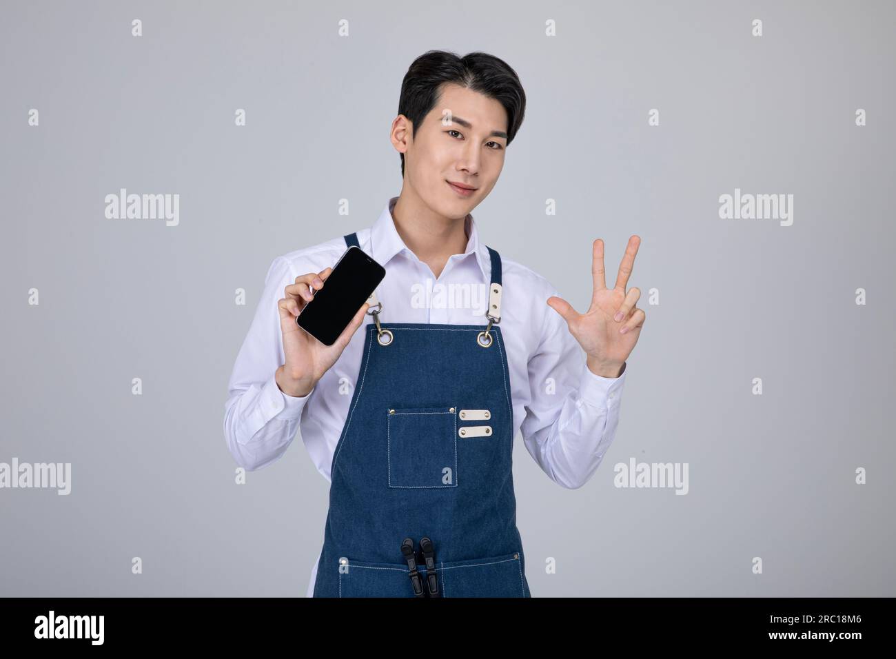 millennials and gen z, korean asian young man holding a smartphone ...