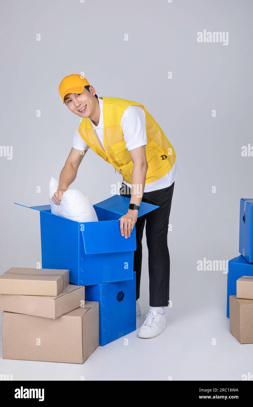 millennials and gen z, korean asian young man organizing moving boxes ...