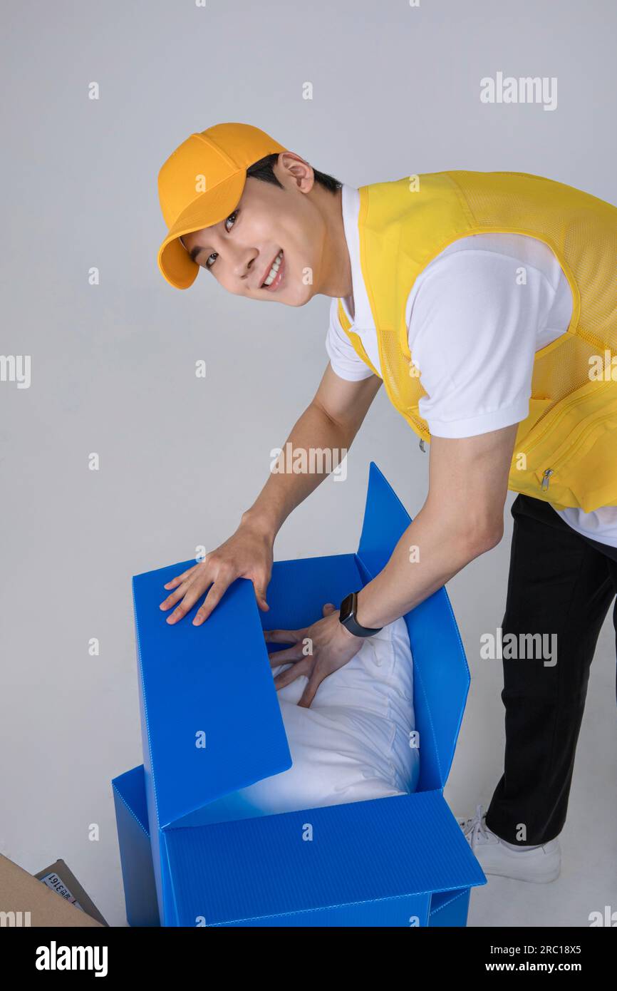 millennials and gen z, korean asian young man organizing moving boxes ...