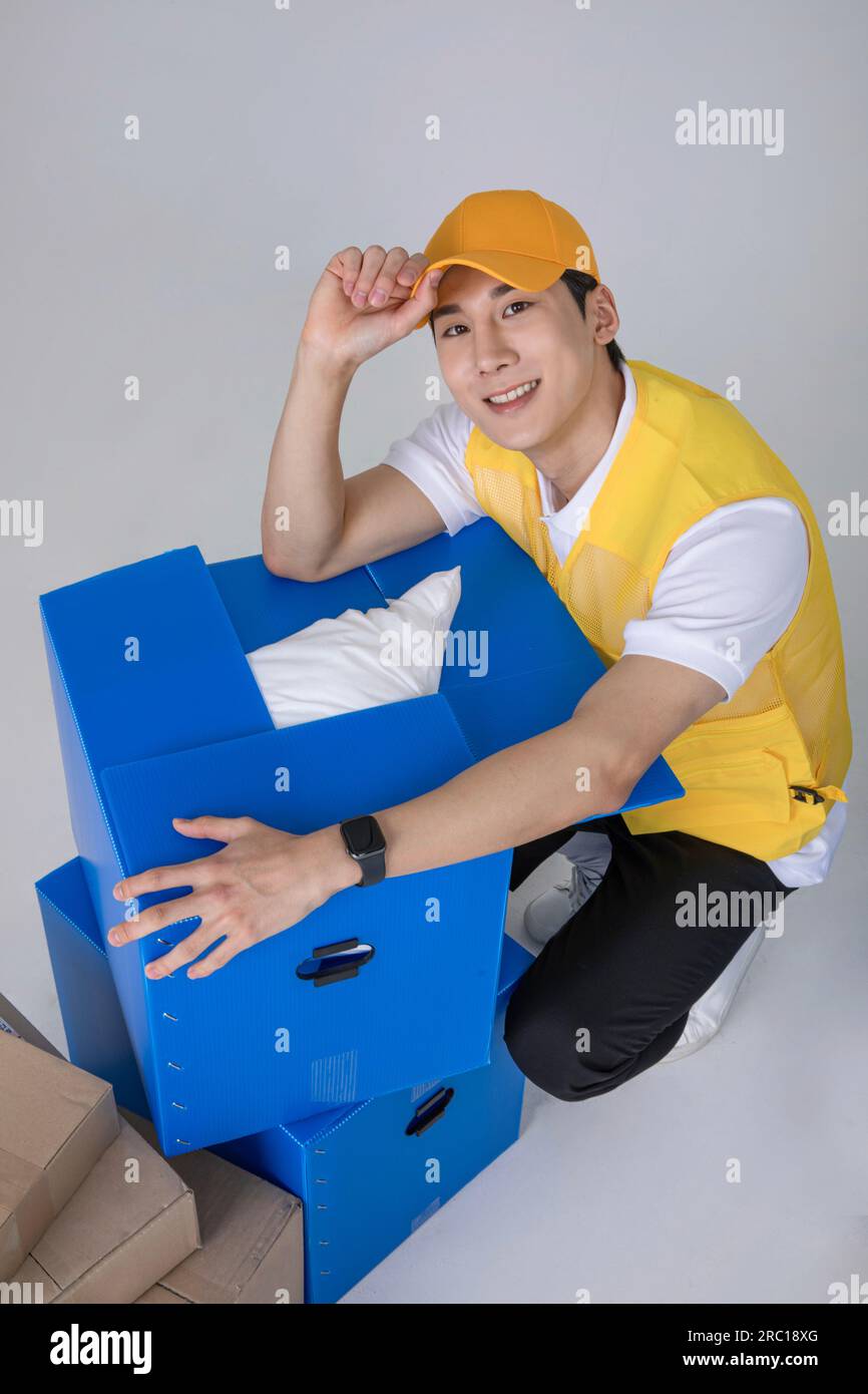 millennials and gen z, korean asian young man organizing moving boxes ...