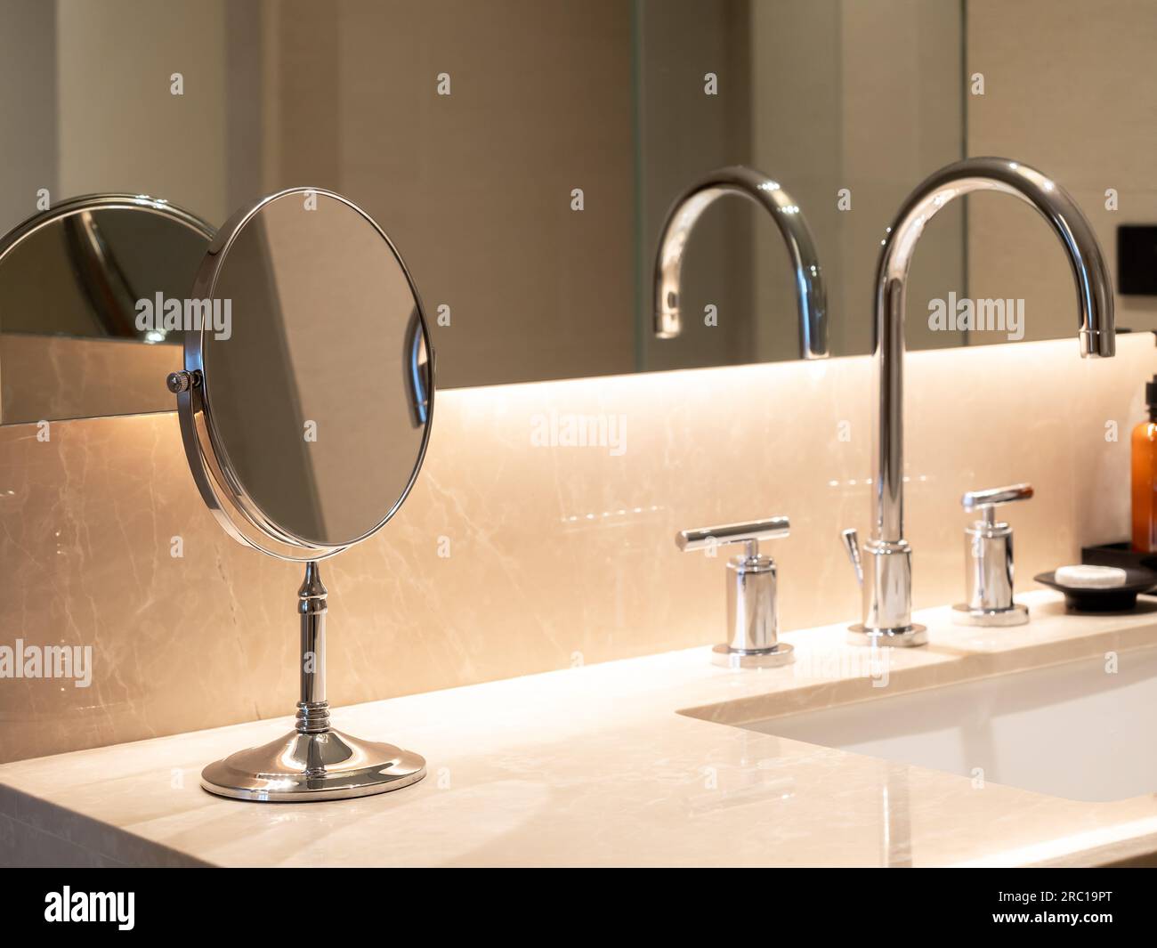 Small folding round makeup mirror standing near sink basin with marble ...